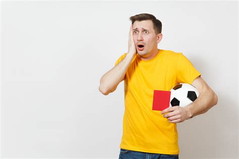 유럽 슬픈 화가 우는 충격된 젊은 남자 흰색 배경에 고립 된 필드에서 축구 팬 이나 손에 빨간색 노란색 유니폼 보류 축구 카드에 선수 은퇴 스포츠 놀이 라이프 스타일