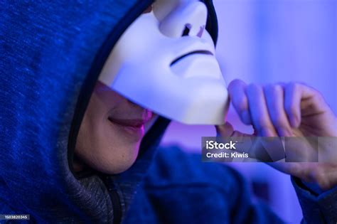 close up of computer hacker wearing mask stealing data from a laptop