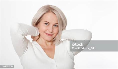 스튜디오에서 감정적으로 포즈를 취하는 행복한 여자 흰색 배경에 노란색 밝은 스웨터에 행복한 여자 50 54세에 대한 스톡 사진 및 기타 이미지 Istock