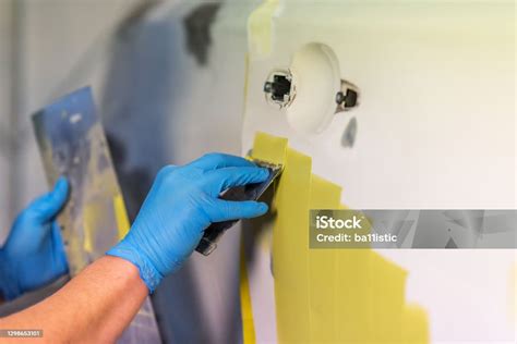 차체 수리 응용 프로그램 퍼티 클로즈업 정비사가 차를 수리합니다 페인팅 전에 샌드링 프라이머를 작업하여 사고 후 작업하십시오