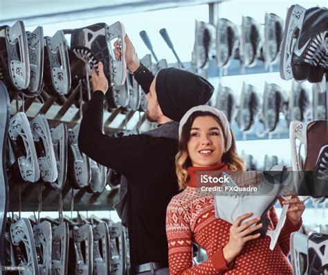 스케이트의 많은 쌍과 랙 근처에 서 따뜻한 옷을 입고 젊은 부부는 자신의 크기를 선택 겨울에 대한 스톡 사진 및 기타 이미지 겨울 겨울 스포츠 계절 Istock