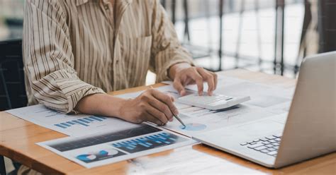 사업가 또는 회계사는 책상 사무실에서 책상에서 일하는 마스크를 착용하고 계산기를 사용하여 숫자 재무 회계 개념을 계산합니다 사진 Unsplash의 코비드 19 이미지