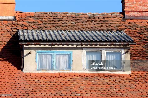 두 개의 붉은 벽돌 굴뚝 옆에 작은 지붕 타일과 녹슨 거 터로 둘러싸인 밝은 파란색과 흰색 낡은 나무 프레임 지붕 창 0명에 대한 스톡 사진 및 기타 이미지 Istock