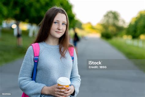 아름 다운 갈색 머리 십 대 소녀입니다 자연에서 여름입니다 그의 손에 뜨거운 차 또는 커피와 함께 유리를 보유 하고있다 텍스트에 대 한 근접 자유 공간입니다 뒤에 가방