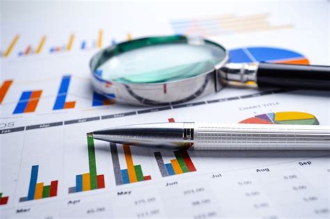Premium Photo Magnifying Glass On Charts Graphs Spreadsheet Paper