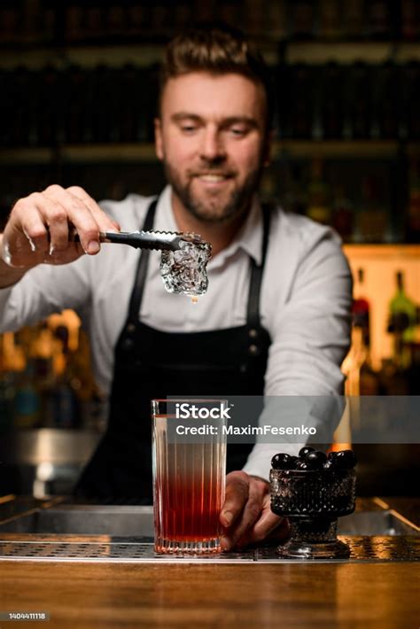 바텐더는 칵테일과 함께 유리 위에 얼음 조각이있는 집게를 들고 있습니다 각얼음에 대한 스톡 사진 및 기타 이미지 각얼음 결정체 근거리 초점 Istock