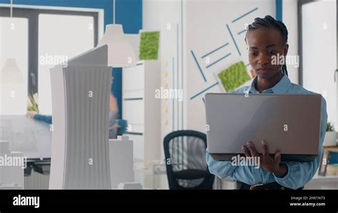 Close Up Of Engineer Looking At Laptop To Analyze Building Model In Architectural Office Woman