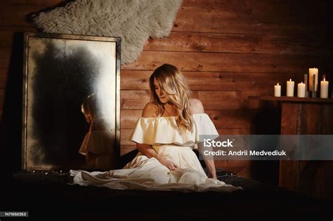 긴 흰색 드레스를 입은 임산부가 별 달이 있는 장식 스튜디오에서 배를 만지고 있다 모성 임신 사람 및 기대 개념 아기를 기대하는 임산부 출산 개념 25 29세에 대한 스톡