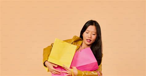 노란 드레스를 입은 여성이 쇼핑백을 들고 있다 사진 Unsplash의 섬유 이미지