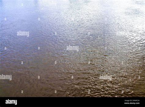 Detailed Close Up View On Water Surfaces With Waves And Ripples And The Sunlight Reflecting At