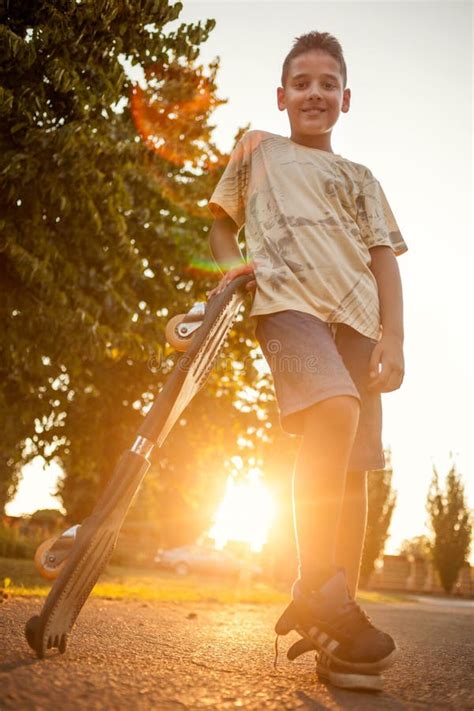 Холодный смотря мальчик конькобежца на заходе солнца Стоковое Фото изображение насчитывающей