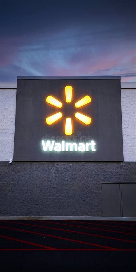 A Night Shot Of A Walmart Superstore Logo On The Front Entrance Of The