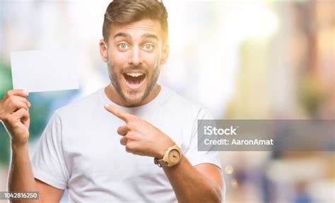손과 손가락으로 가리키는 매우 행복 격리 된 배경 위에 빈 카드를 들고 젊은 잘생긴 남자 가리키기에 대한 스톡 사진 및 기타 이미지 가리키기 감정 공란 Istock