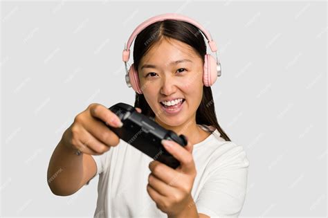 Premium Photo Young Asian Gamer Woman Playing With A Game Controller And Headphones Isolated