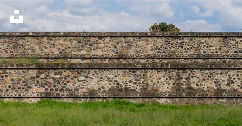 한 남자가 스케이트보드를 타고 돌담 옆 거리를 걷고 있다 사진 Unsplash의 무료 멕시코 이미지