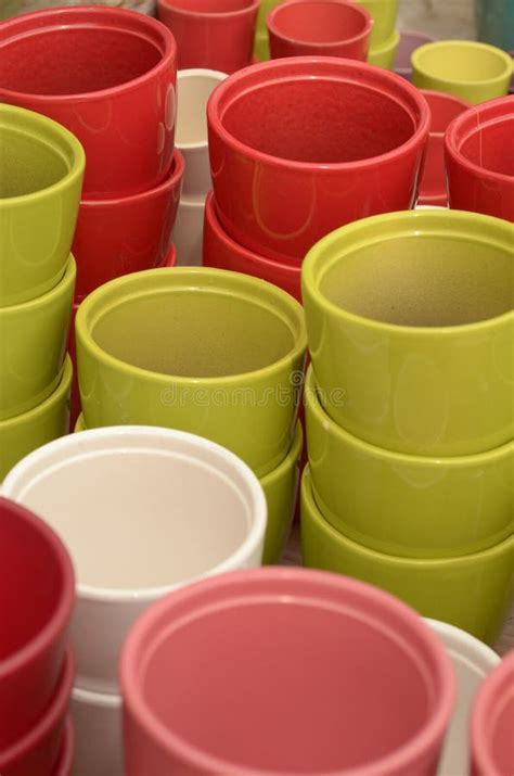 Colorful Yellow And Red Ceramic Flower Pots Stacked On A Shelf Stock