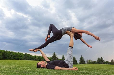 Premium Photo Healthy Man Lying On Grass And Balancing Woman Couple