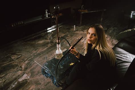 사용자 지정 V8 자동차 엔진 테이블 럭셔리 인테리어에 젊은 백인 금발 여자 흡연 뱃 가죽 소파와 아름 다운 미소 V8에 대한