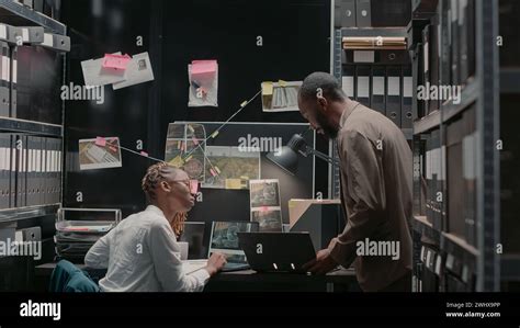 Private Detectives Checking Crime Scene Photos On Map Working To Find Suspect In Police