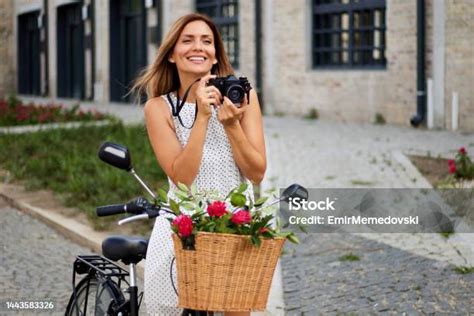 자전거를 들고 카메라를 들고 야외에서 사진을 찍는 젊은 여성 꽃 식물에 대한 스톡 사진 및 기타 이미지 꽃 식물 도시 거리 두발자전거 Istock