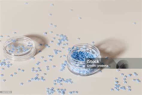 손톱 장식을 위한 요소 네일 액세서리 상자의 파란색 별 베이지색 배경에 유리 항아리에 있는 네일 아트용 별 복사 공간 창조적 인 아름다움 개념 파스텔 색상 사진 시각적