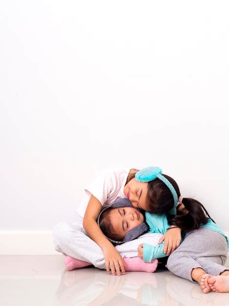 Premium Photo Sisters Sleeping On Floor Against Wall
