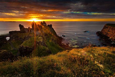 Download Sunset Through Dunluce Castle In Northern Ireland Wallpaper