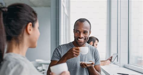 캐주얼 복장을 한 다문화 직원들의 초상화 유리 벽 뒤에 현대적인 사무실 인테리어에서 작업 과정에서 커피 브레이크를 즐기면서 웃고 있다 사진 Unsplash의 우크라이나 이미지