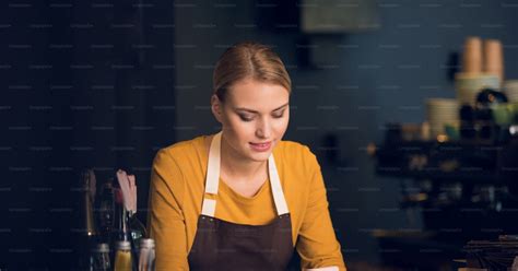 웃고 있는 젊은 여성 바리스타가 아늑한 과자 가게에 서서 모바일로 타이핑하는 초상화 휴식 개념 사진 Unsplash의 초상 이미지