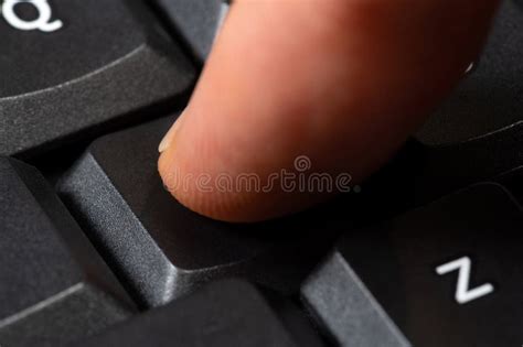 Close Up Shot Of A Finger Mid Action As It Presses An Unlabeled Black Key On A Modern Computer
