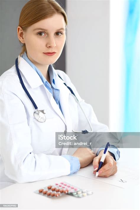 의사 여자 진료소 또는 병원에 창문 가까이 앉아있는 동안 처방전 또는 의료 기록 양식을 작성 의학 및 건강 관리 개념입니다 직장에서 의사 간호사에 대한 스톡 사진 및 기타