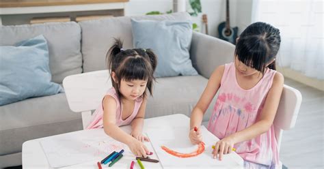 아시아 어린 소녀 아이들은 거실에서 그림을 그리고 색칠합니다 작은 사랑스러운 형제 자매는 테이블에 앉아 집에서 휴일에 창의력 활동을 즐기는 예술 그림을 스케치하는 방법을