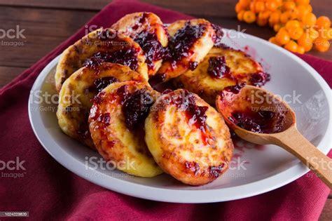 코 티 지 치즈는 나무 바탕에 팬케이크 전통적인 우크라이나 접시빨간 냅킨에 잼 Syrniki 여 보와로 웬 흰색 접시에 코 티