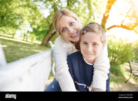 Portrait Of Mother And Son Sitting On Bench In Park Stock Photo Alamy