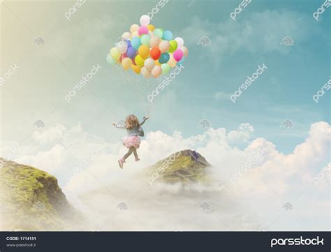 دختر کوچکی که بادکنک های رنگارنگ در دست دارد و از یک کوه به کوه دیگر می