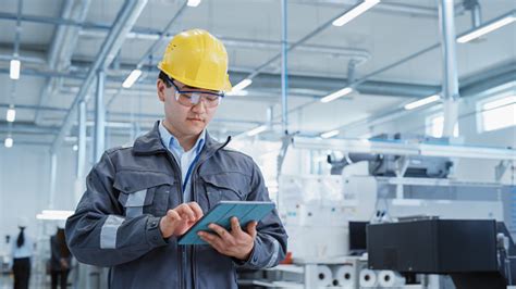 공장 시설에서 엔지니어로 일하면서 작업 재킷 안전 안경 및 노란색 하드 모자를 착용 한 젊은 아시아 남자의 초상화 태블릿 컴퓨터에서 일하는 중공업 전문가 Brand Name