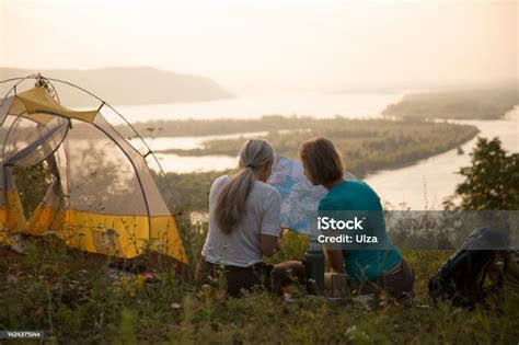 배낭을 든 두 명의 중년 여성 친구는 산에 서서 자연에서 하이킹을하고지도를보고 함께 시간을 보냅니다 여행 관광 개념 주말에는 야외 활동 2명에 대한 스톡 사진 및 기타