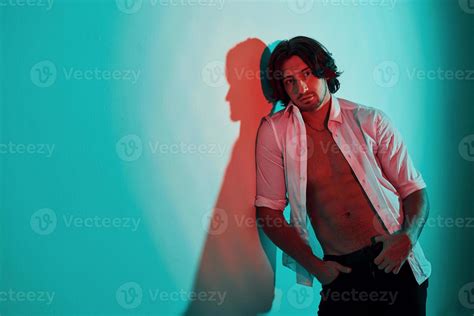 Portrait Of Young Hot Man That Stands In Neon Lights In The Studio