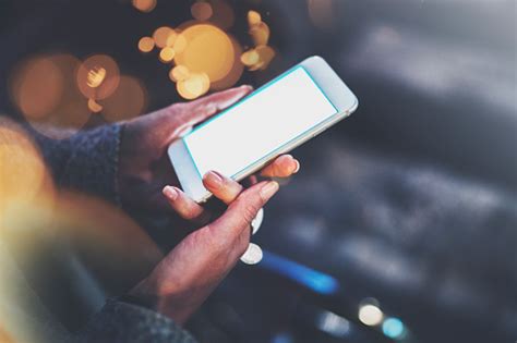 여자 박 대기 시에 손에 스마트폰 들고입니다 여성 손 휴대 전화를 사용 하 여입니다 배경 흐리게에 근접 촬영 플레어 Bokeh 효과 가리키기에 대한 스톡 사진 및 기타