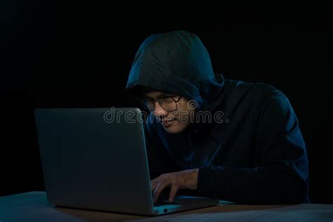 Asian Hacker Hacking Computer Network With Laptop In Dark Cyber Security Concept Stock Photo