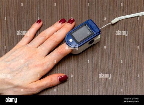 Pulse Oximeter Device On Female Index Finger Measuring Pulse And Oxygen Saturation Inside Red
