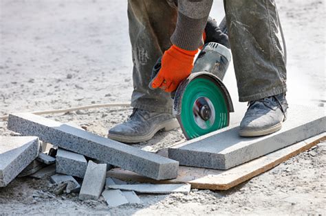 건축업자는 다이아몬드 블레이드로 작동하는 전기 톱을 들고 작업장 배경에 화강암 블록을 잘라 클로즈업 흐리게 배경 개선에 대한 스톡 사진 및 기타 이미지 Istock