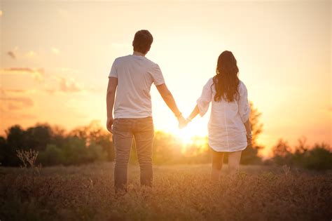 Фото Девушка и парень смотрят на закат держась за руки