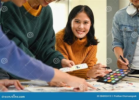 Smiling Young Creative Woman Discussing New App Features With Her Colleagues During Meeting At
