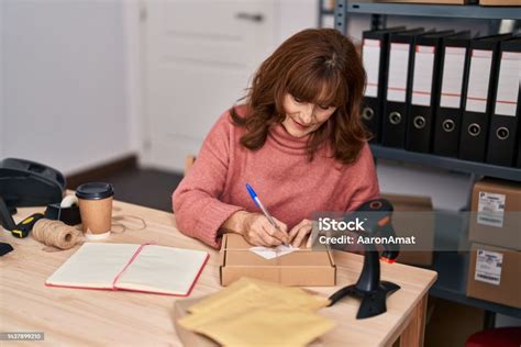 중년 여성 전자 상거래 비즈니스 근로자가 사무실에서 패키지에 글을 씁니다 55 59세에 대한 스톡 사진 및 기타 이미지 55 59세 기업가 나무 상자 Istock
