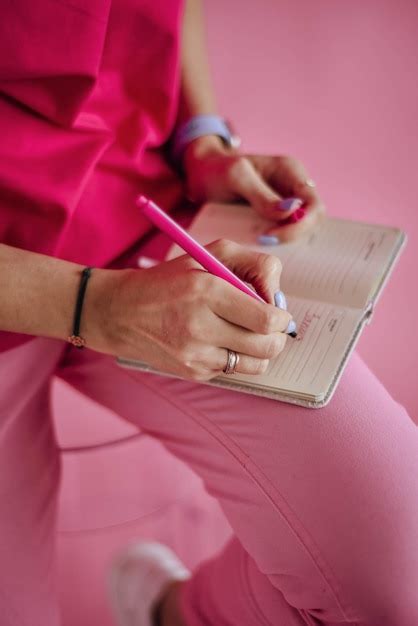 Premium Photo A Woman In Pink Is Writing On A Pink Notebook