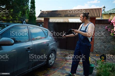 파란색 작업복을 입은 잘생긴 근육질의 매력적인 젊은 성인 남성 고압 워터 제트기로 수동으로 세차 40 44세에 대한 스톡 사진 및 기타 이미지 Istock