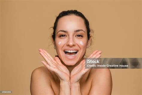 웃는 소녀 화장품 케어 크림을 적용 얼굴 미용 제품을 사용하여 고립 된 베이지 색 배경 25 29세에 대한 스톡 사진 및 기타 이미지 Istock