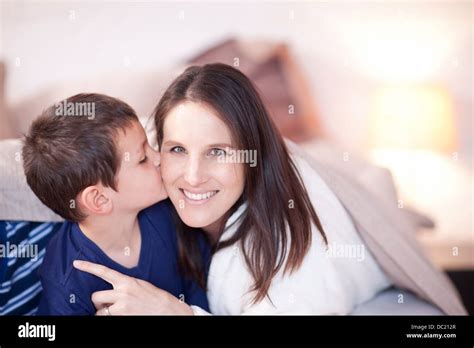 Son Kissing Mothers Cheek Under Duvet Stock Photo Alamy