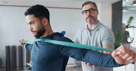 물리 치료 저항 밴드 및 재활 건강 관리 또는 스트레칭을 위해 클리닉에서 남성 및 운동 선수와 상담 치유 조언 또는 회복을 위해 사람들과 함께 지원 의료 및 근육 건강관리와